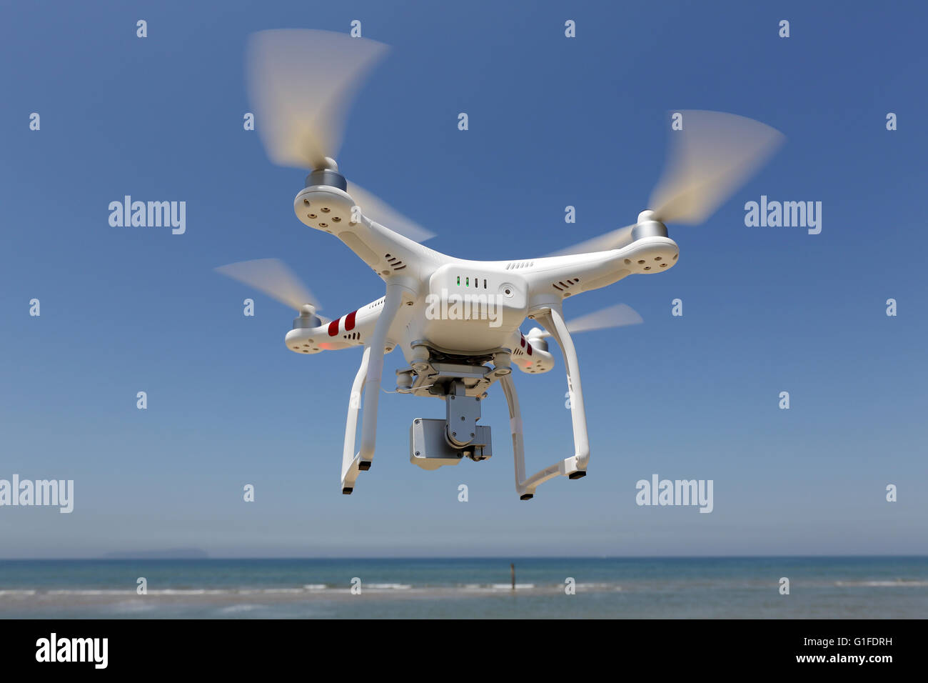 White drone quad copter with flying in the clear blue sky Stock Photo ...