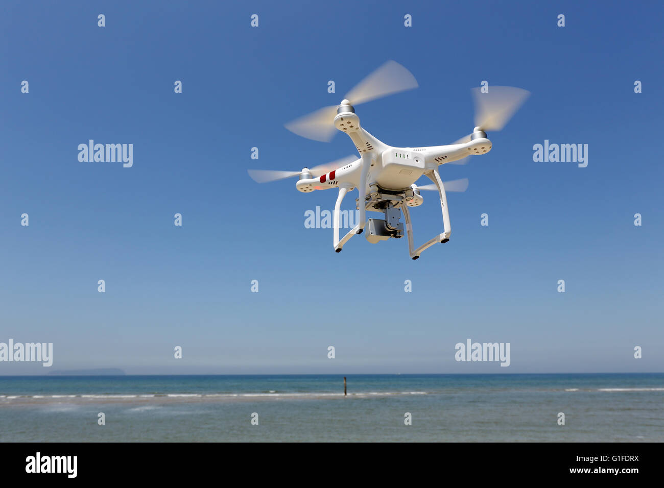 White drone quad copter with flying in the clear blue sky Stock Photo ...