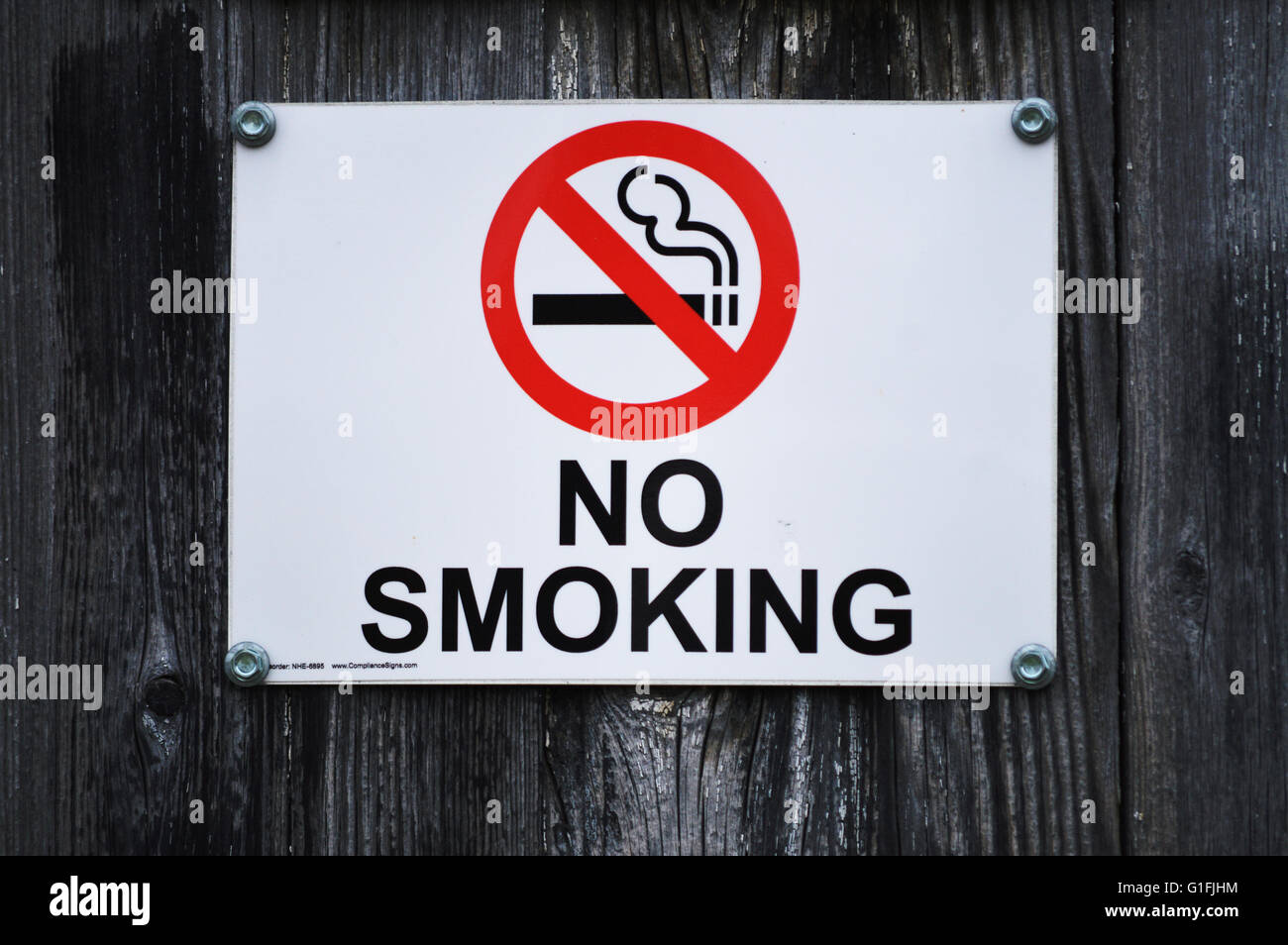 A standard no smoking sign held up by bolts on rustic wood Stock Photo ...