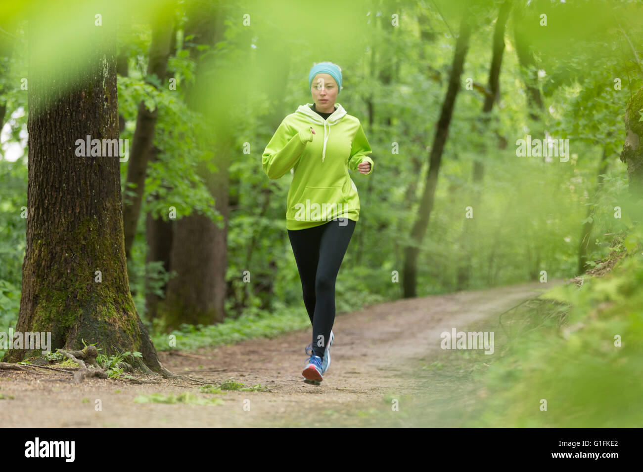 Sporty young female runner in the forest Stock Photo - Alamy