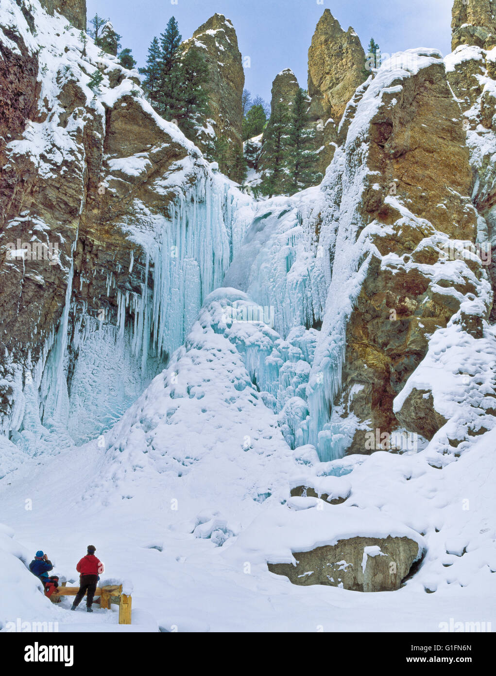 winter tourists below frozen tower falls in yellowstone national park ...