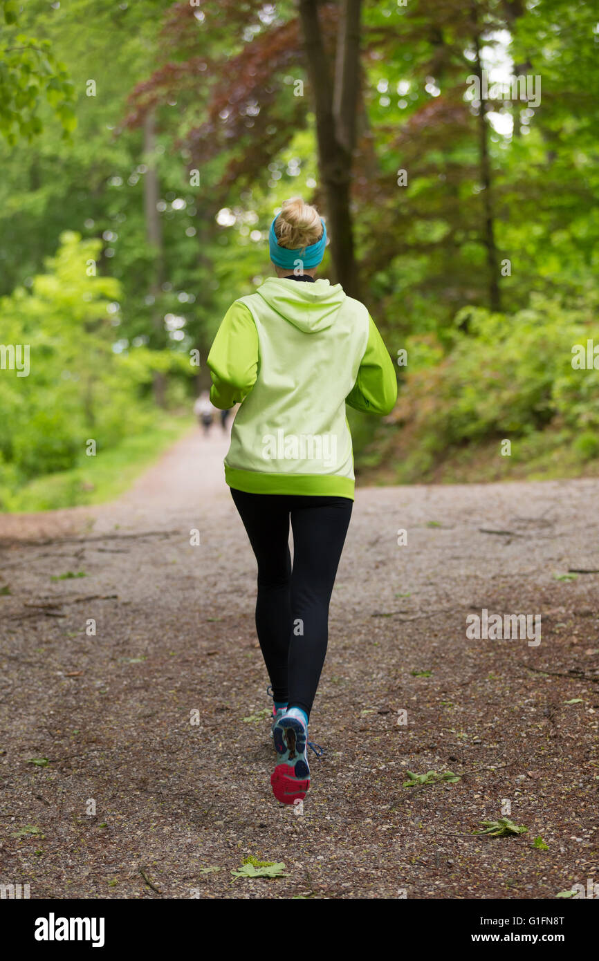 Sporty young female runner in the forest Stock Photo - Alamy