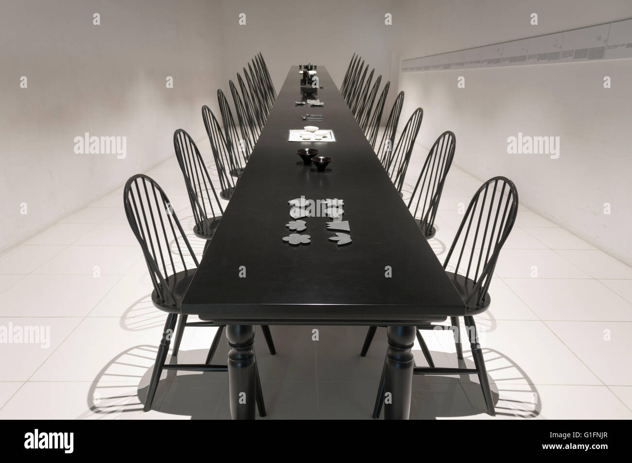Very long black dining table in white room Stock Photo - Alamy