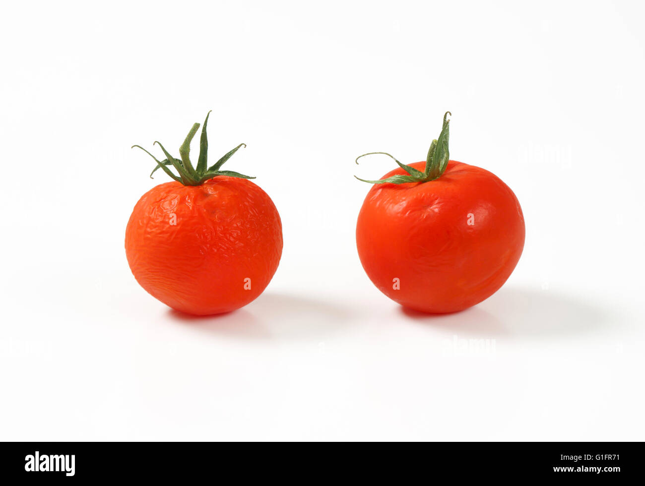 two tomatoes going bad, on white background Stock Photo - Alamy