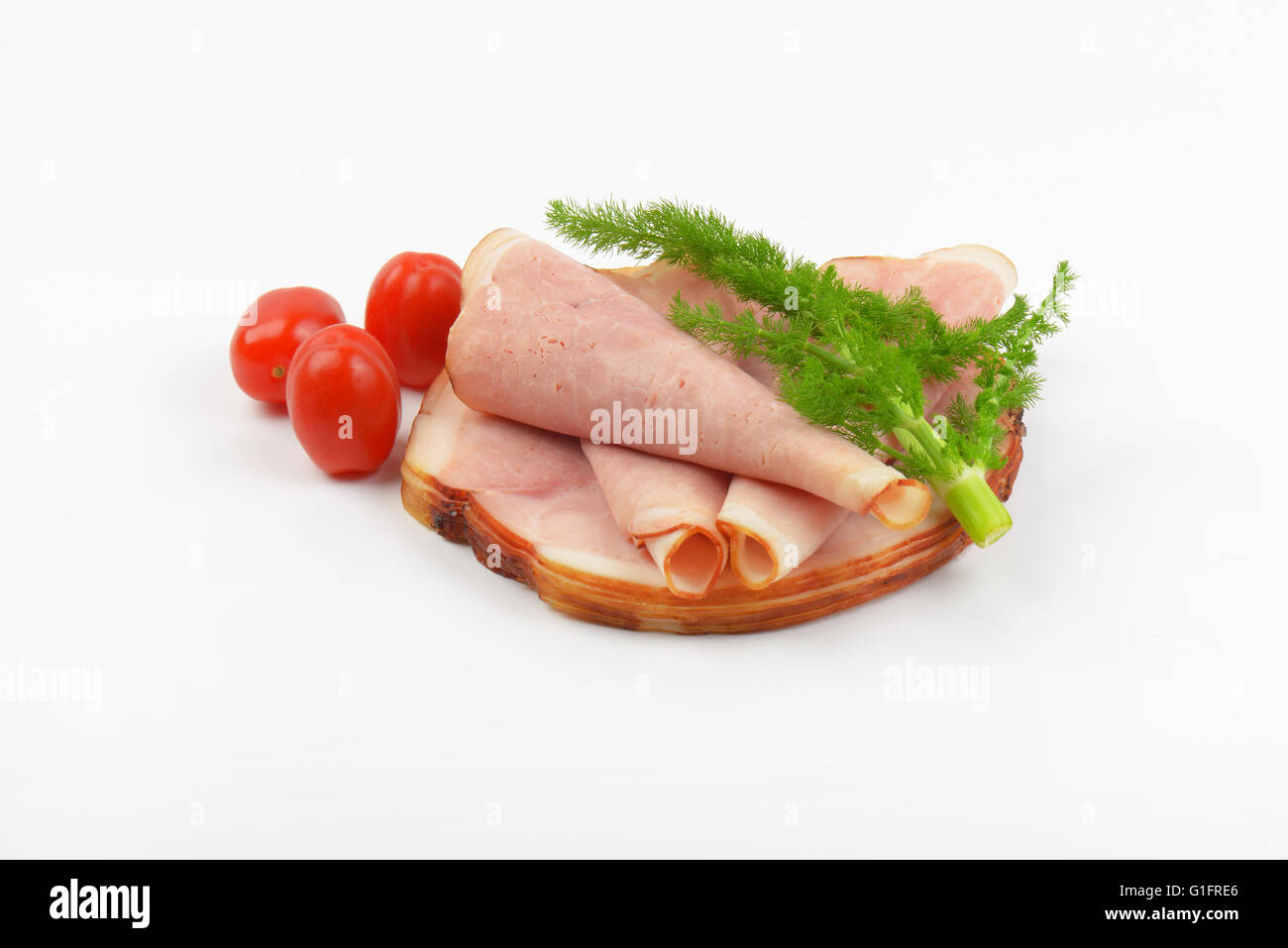 stack of ham slices with fresh dill and cherry tomatoes on white ...