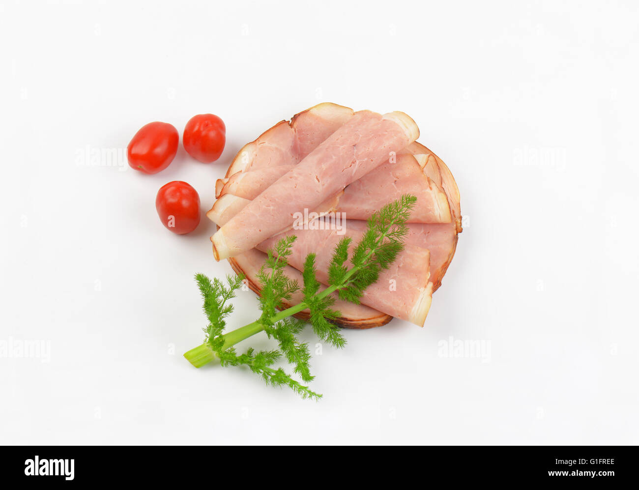 stack of ham slices with fresh dill and cherry tomatoes on white ...