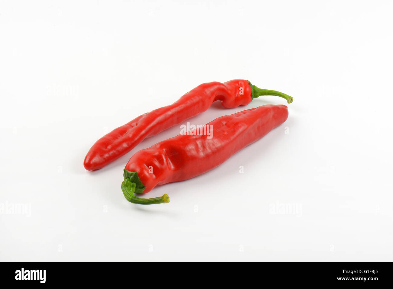 two red peppers on white background Stock Photo - Alamy