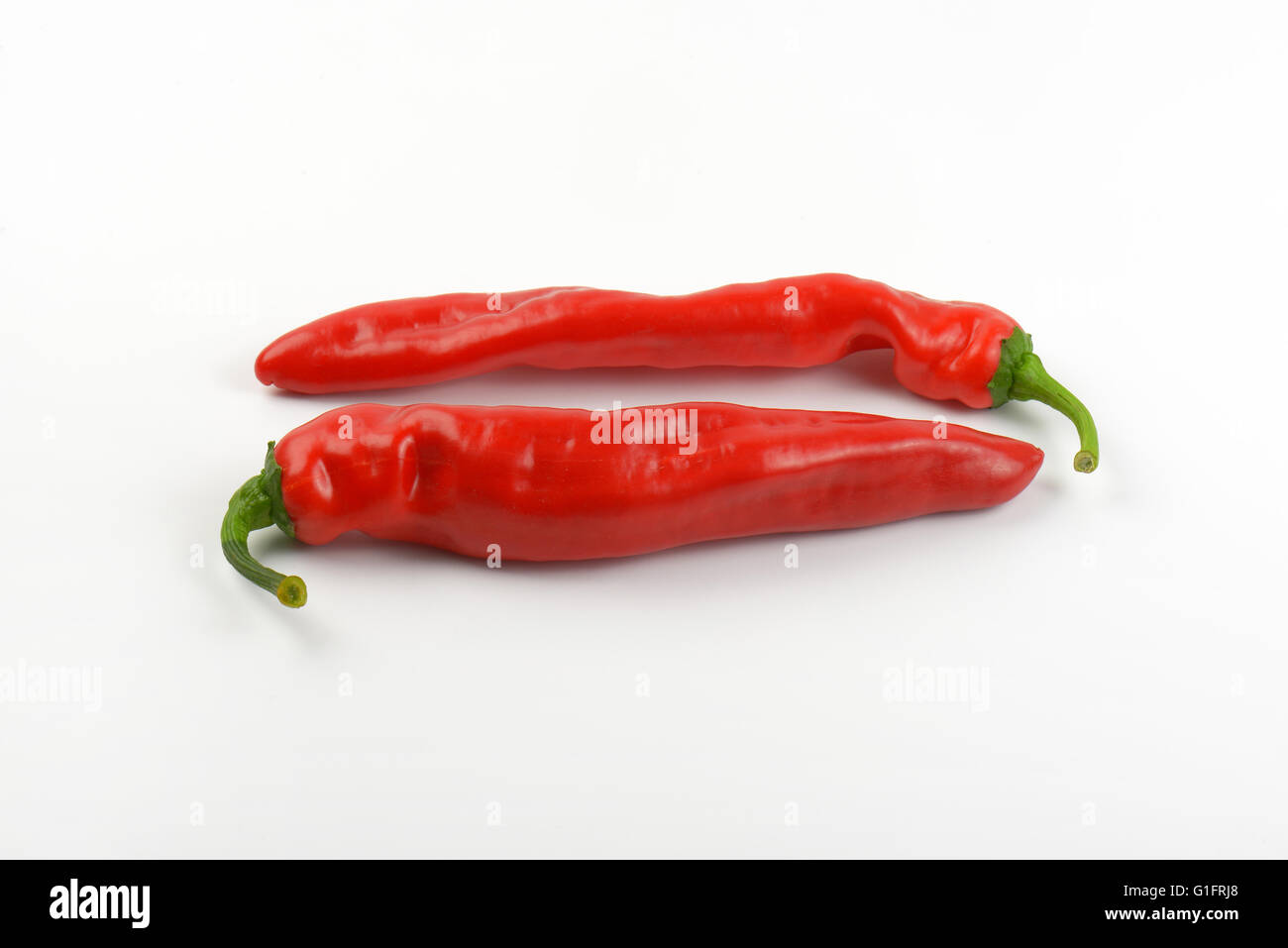 two red peppers on white background Stock Photo - Alamy