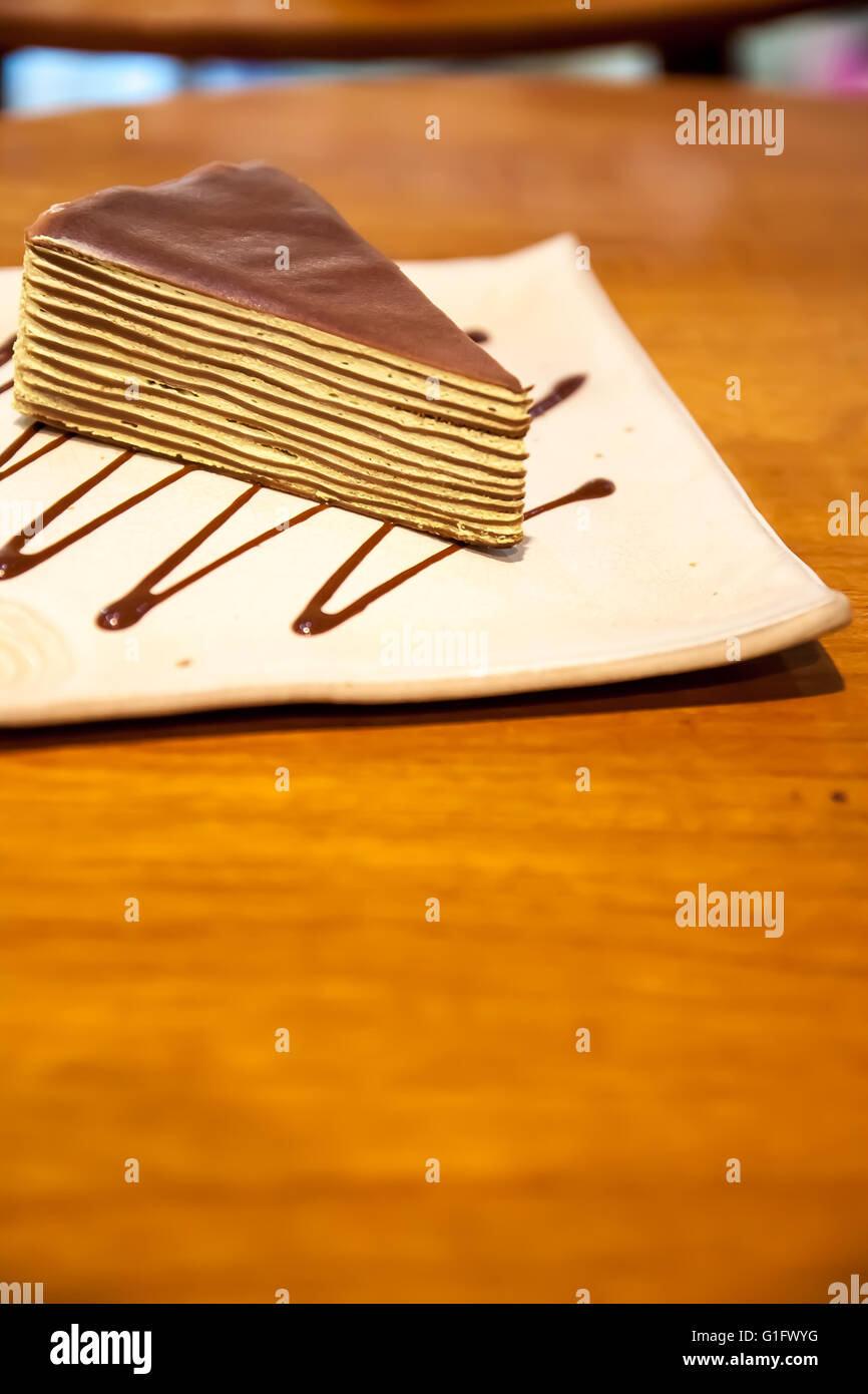Crepe cake in square japanese-style dish on the wood table with zigzag ...