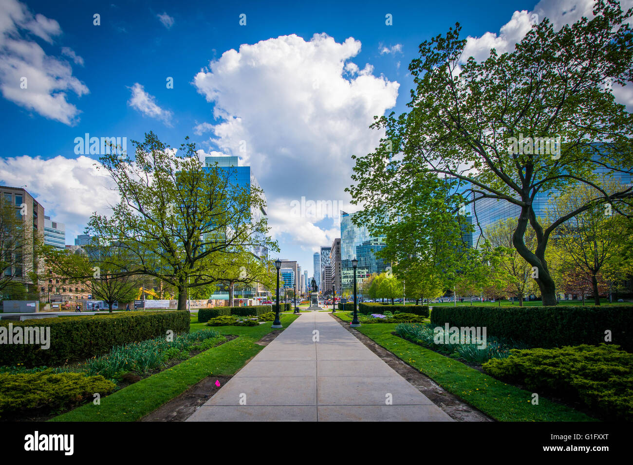 Trees and gardens along a walkway at Queen's Park, in Toronto, Ontario ...