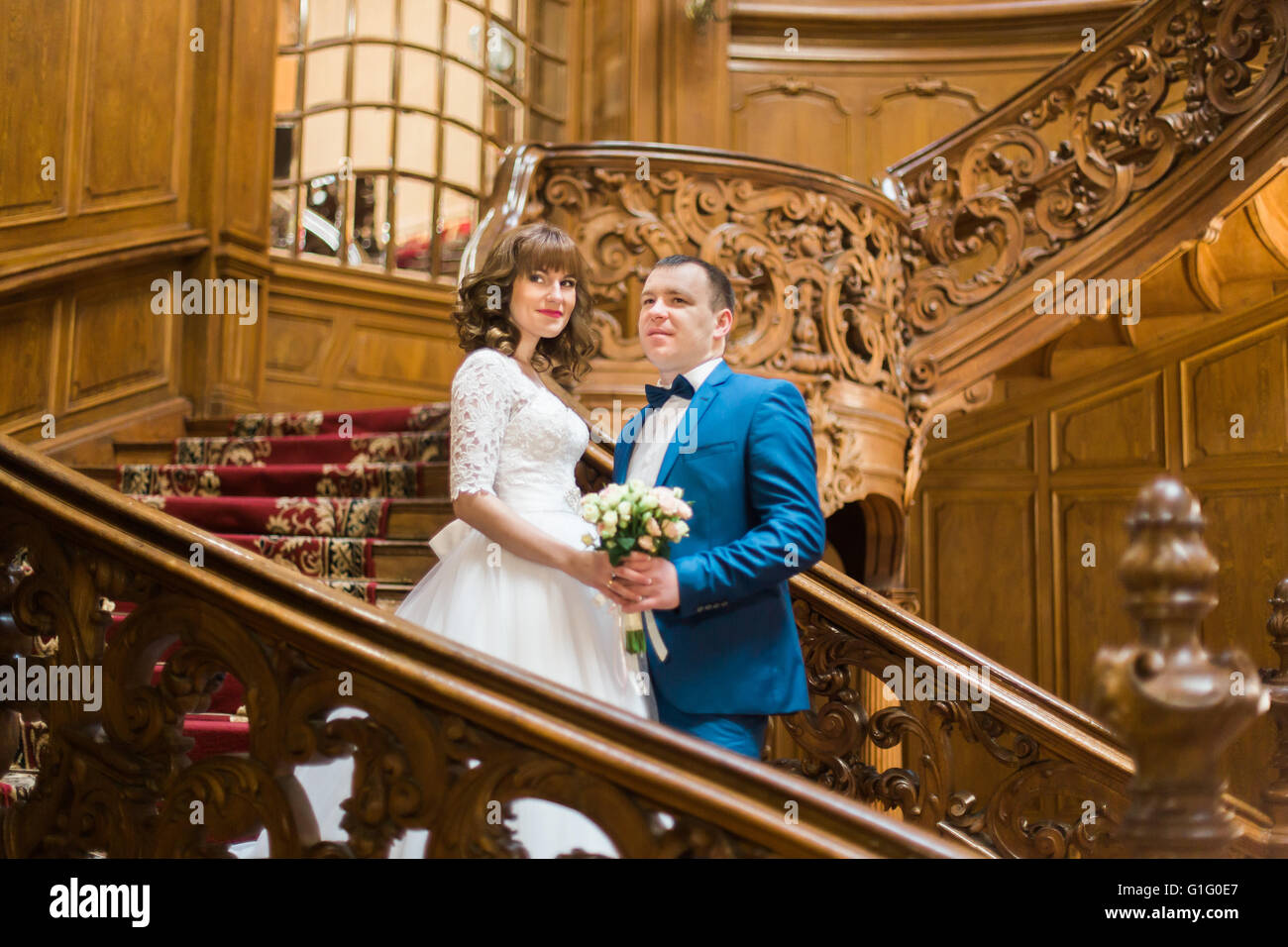 Stylish luxury bride and handsome elegant groom posing holding hands ...
