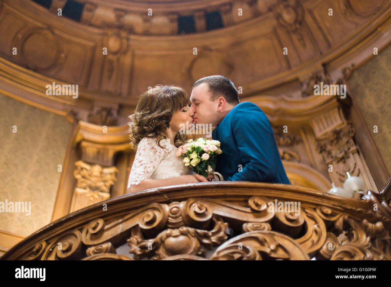 Close-up portrait of happy married couple kissing on wooden balcony at ...