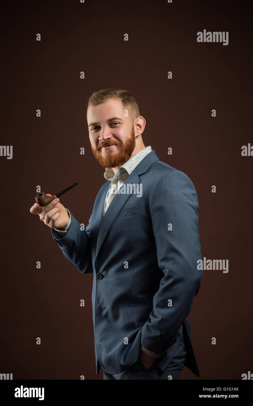 Elegant smiling man with beard holding smoking pipe Stock Photo - Alamy