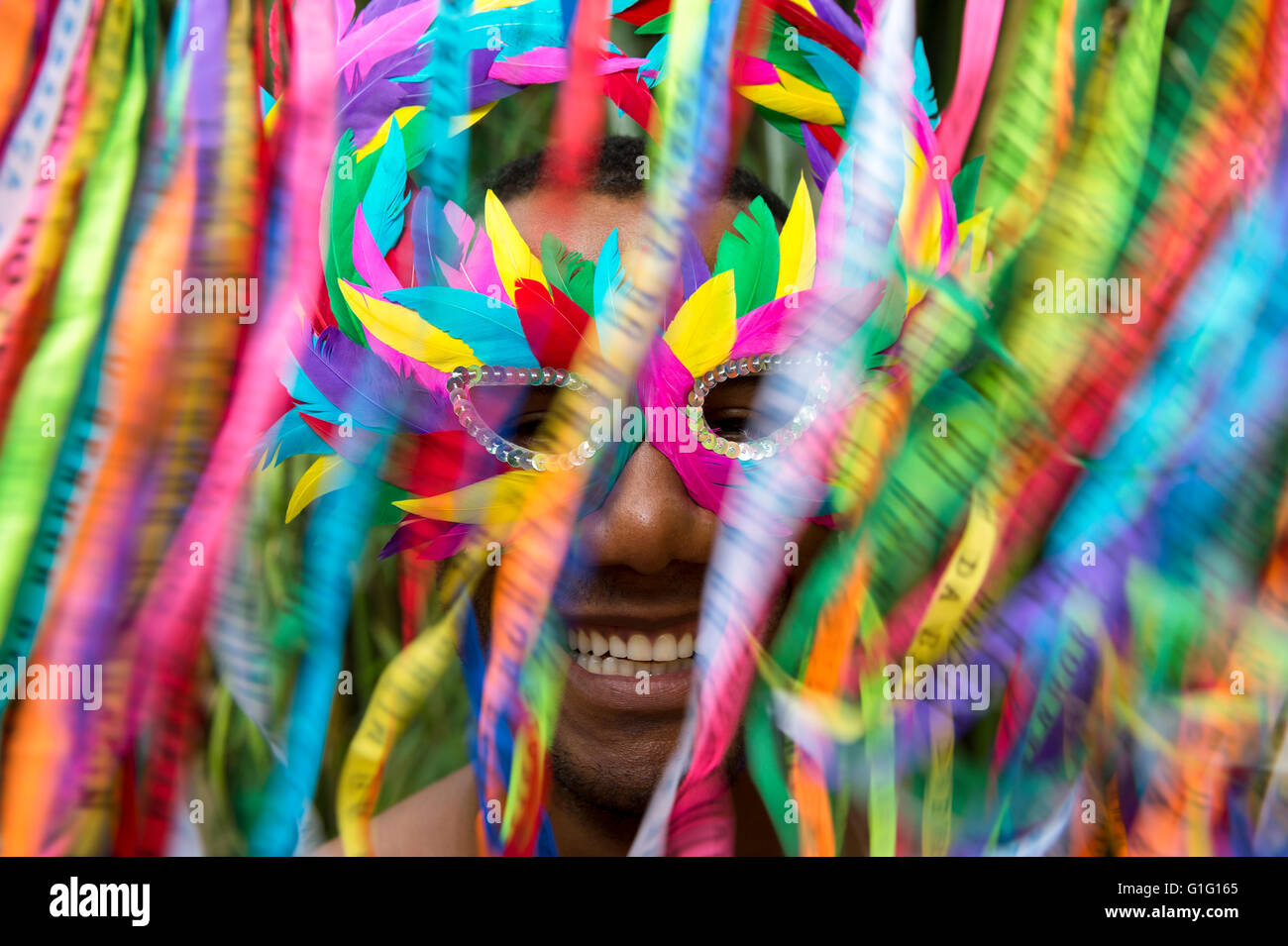 Rio Carnival scene features smiling Brazilian man in colorful mask with ...