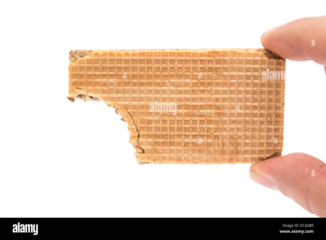 fingers holding piece of wafer block with a bite on white background ...