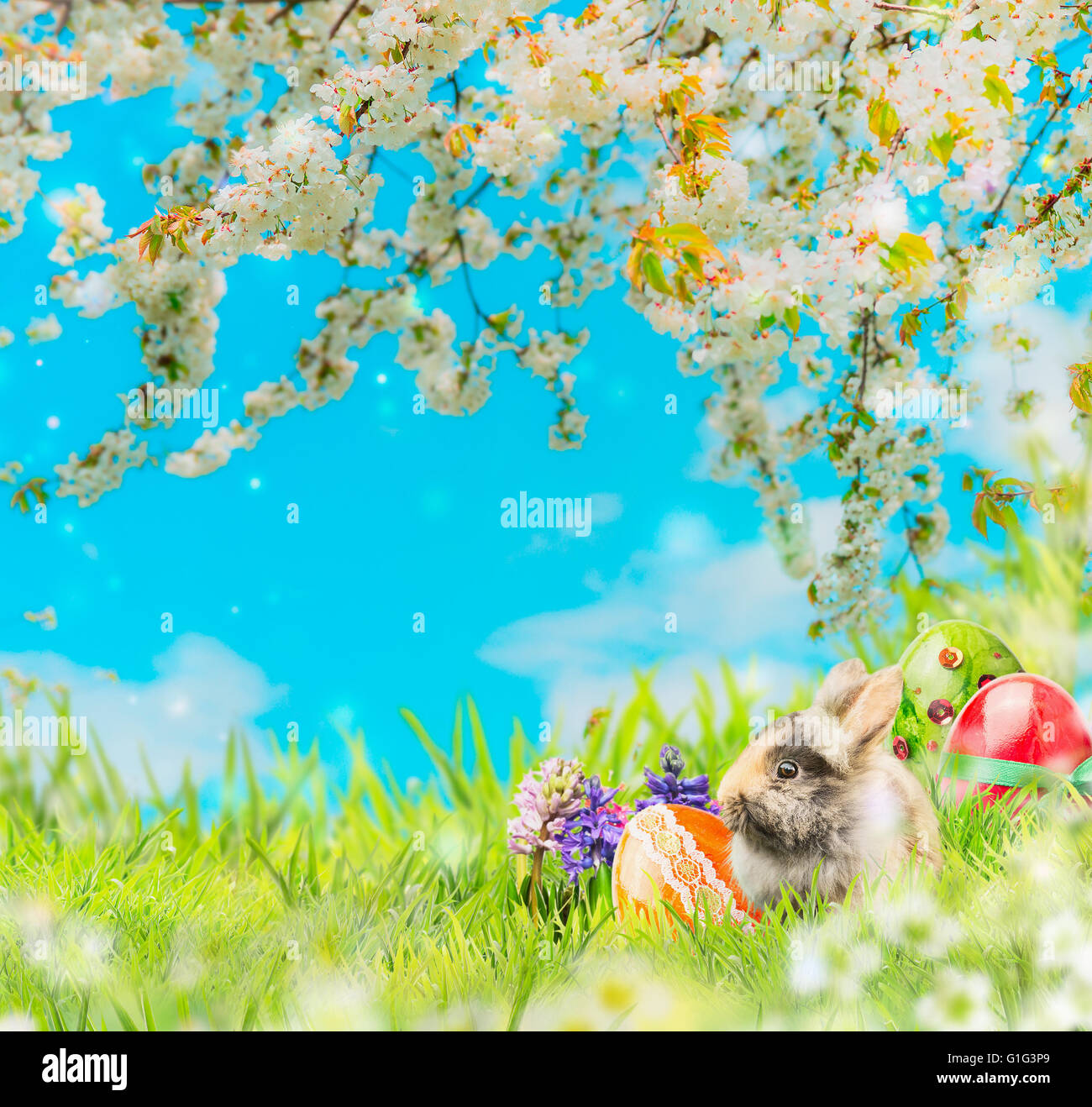 Little Easter bunny with spring flowers and easter eggs under branch of ...