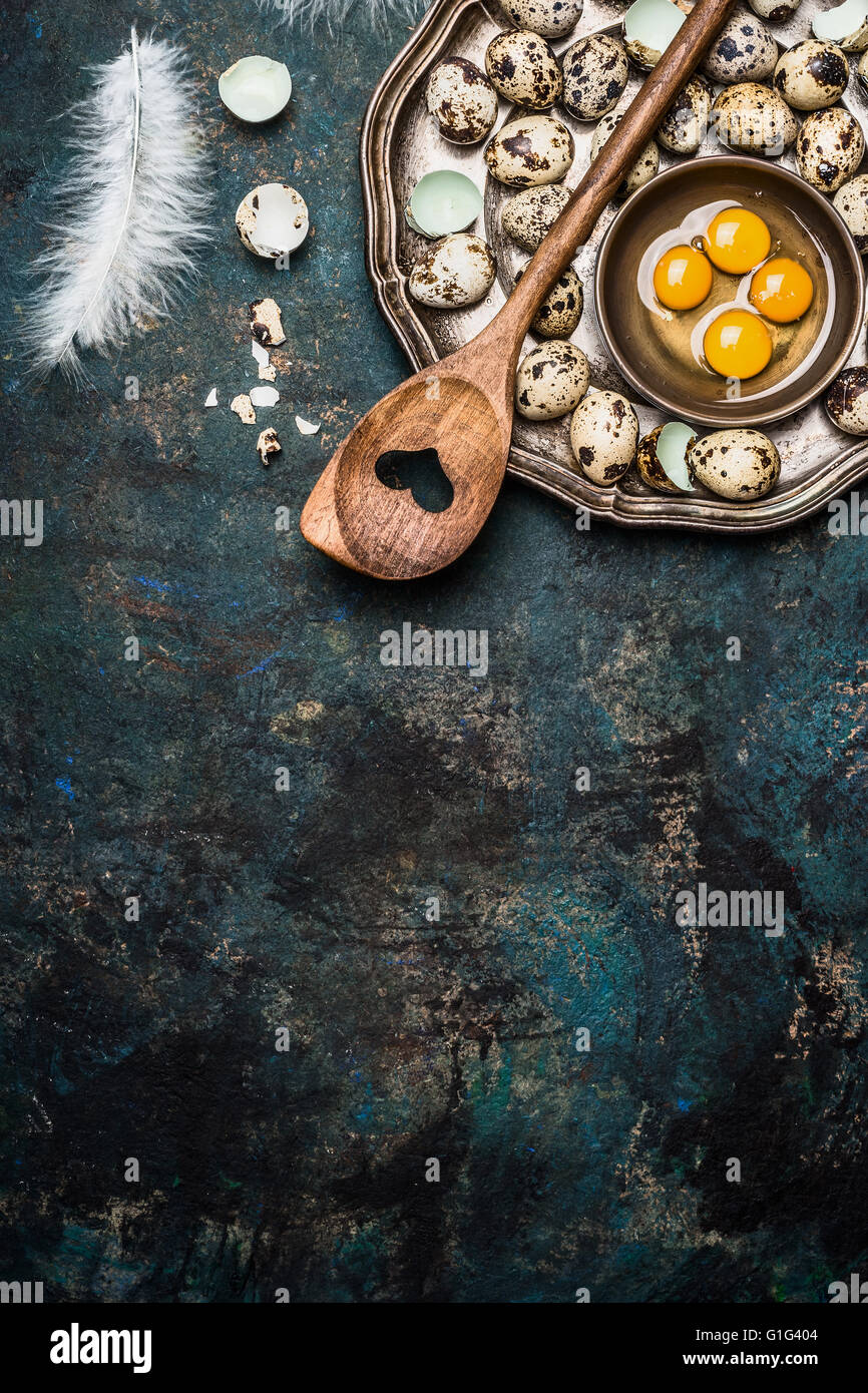 Quail eggs with cooking spoon on rustic background, top view. Broken ...
