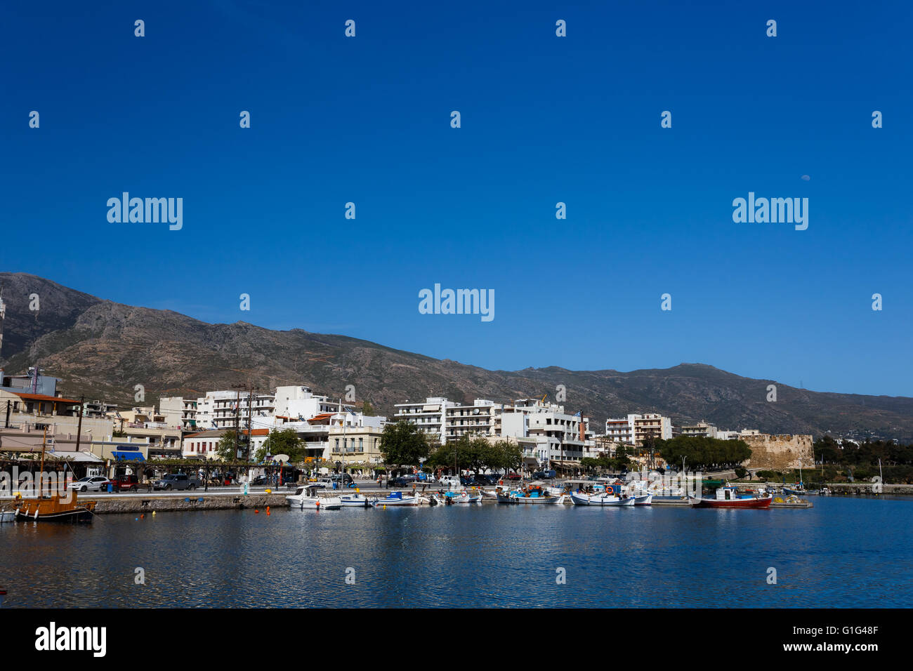 Nea Stira port with anchored fish boats against a blue sky and blue ...