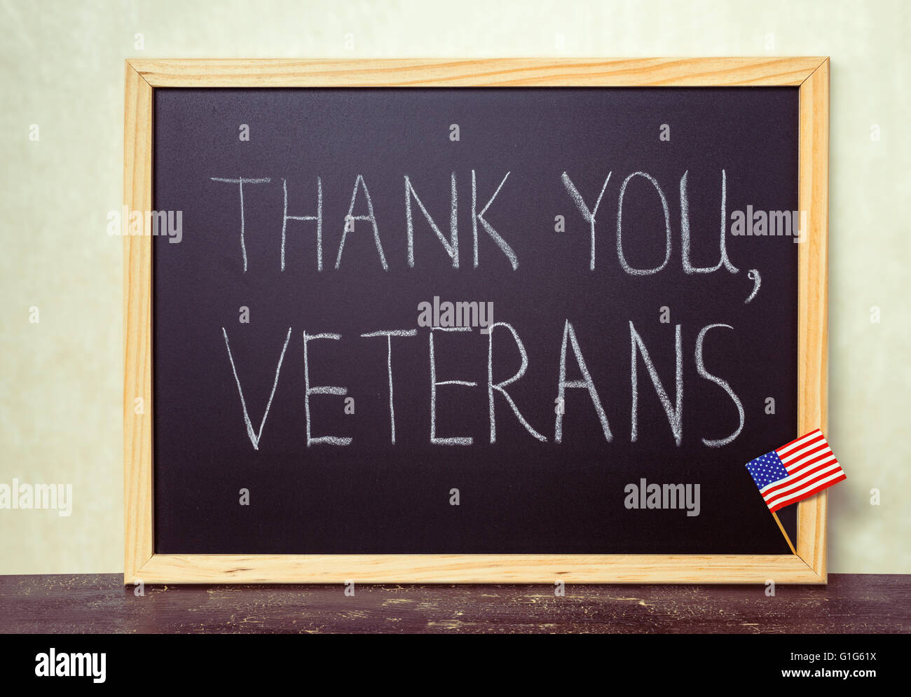 handwriting text thank you veterans is written in chalkboard with flag ...