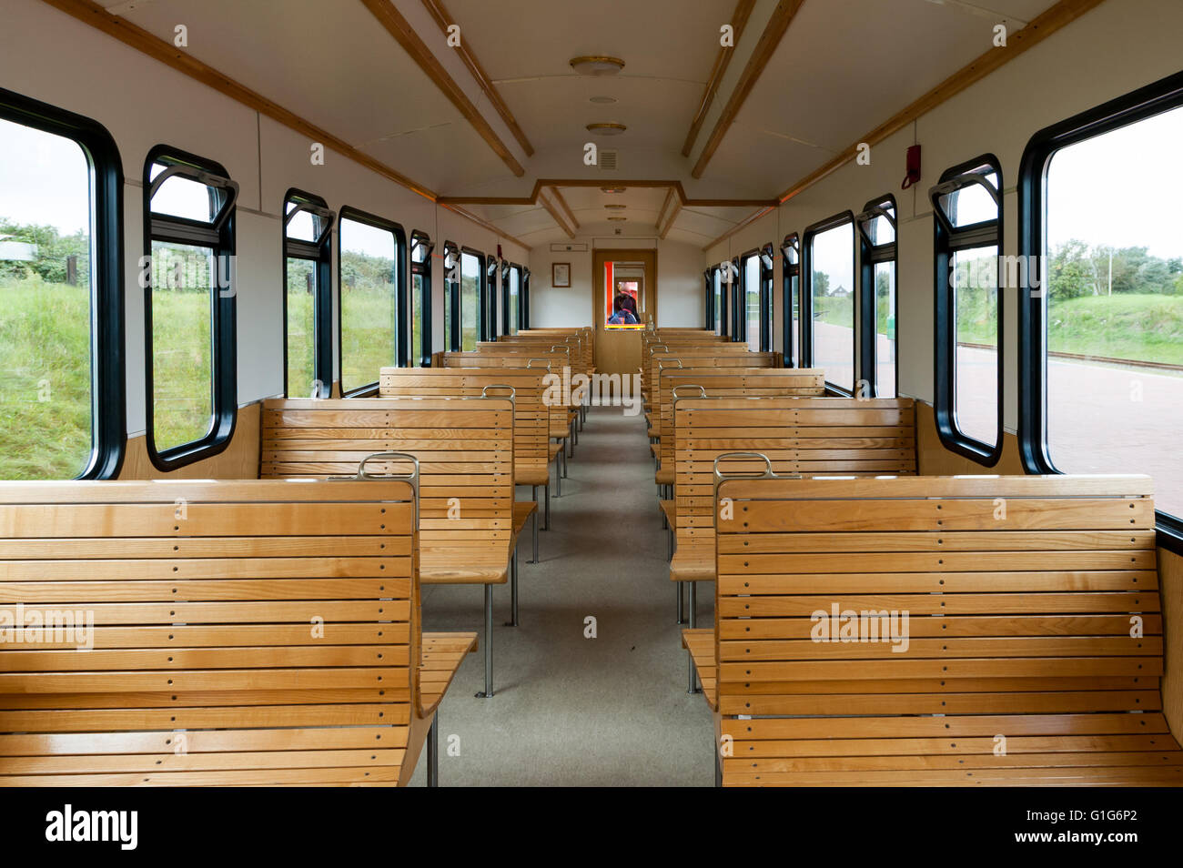 Rows of wooden seats in old passenger car of traditional train on the ...