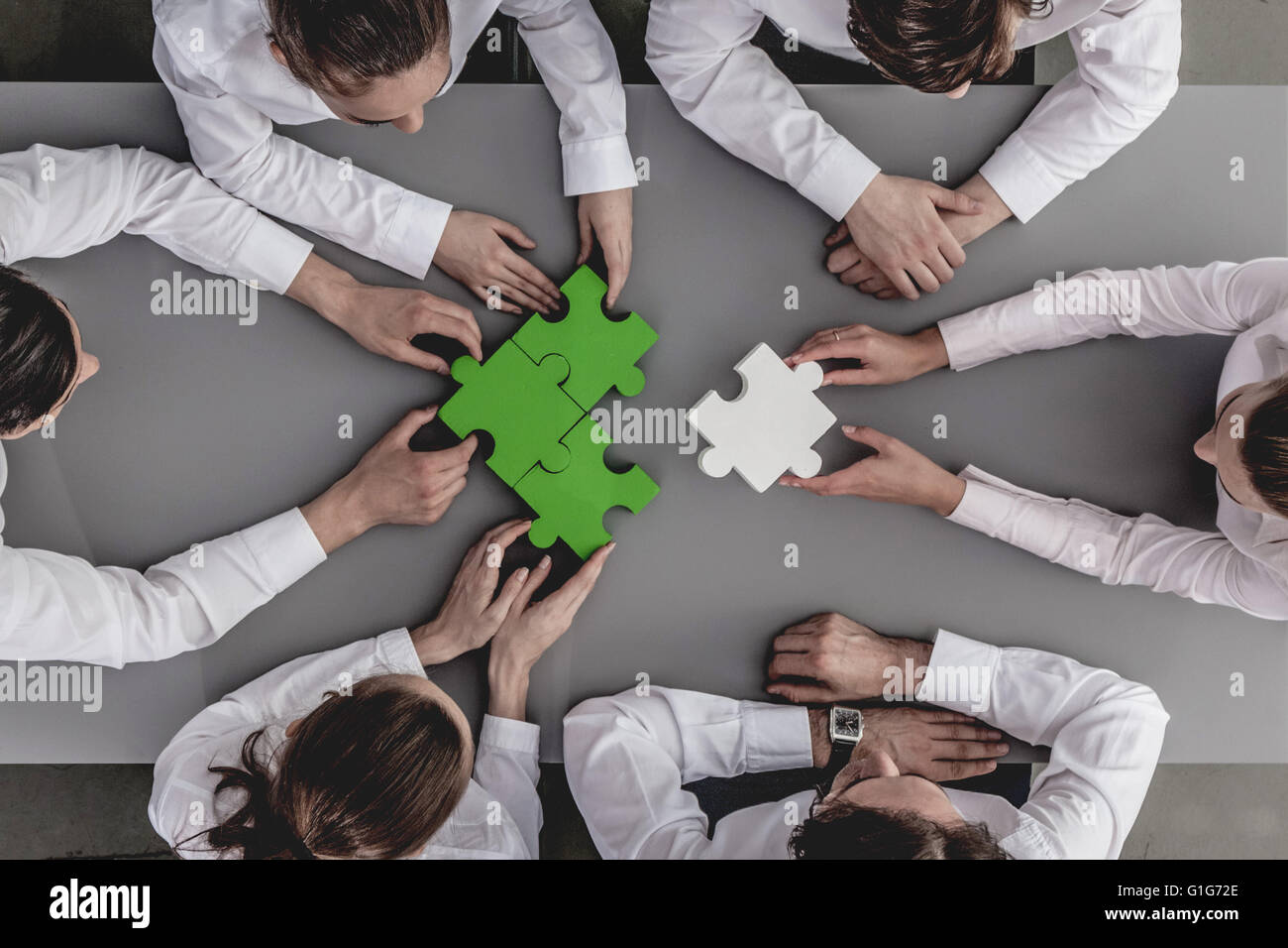 Group of business people assembling jigsaw puzzle and represent team ...