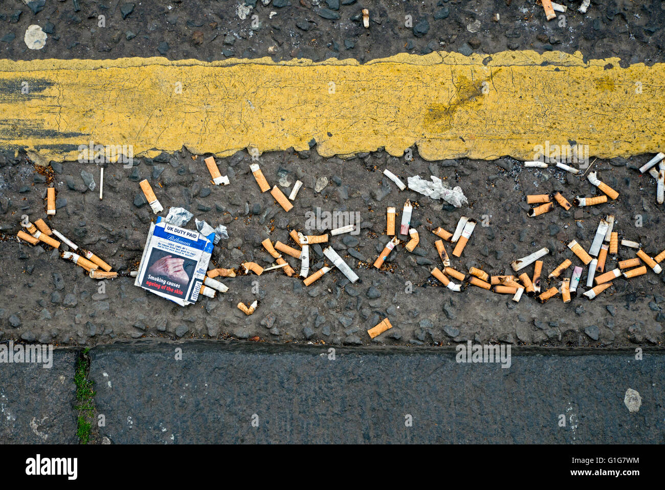 An empty cigarette packet and cigarette ends in lying in the gutter ...