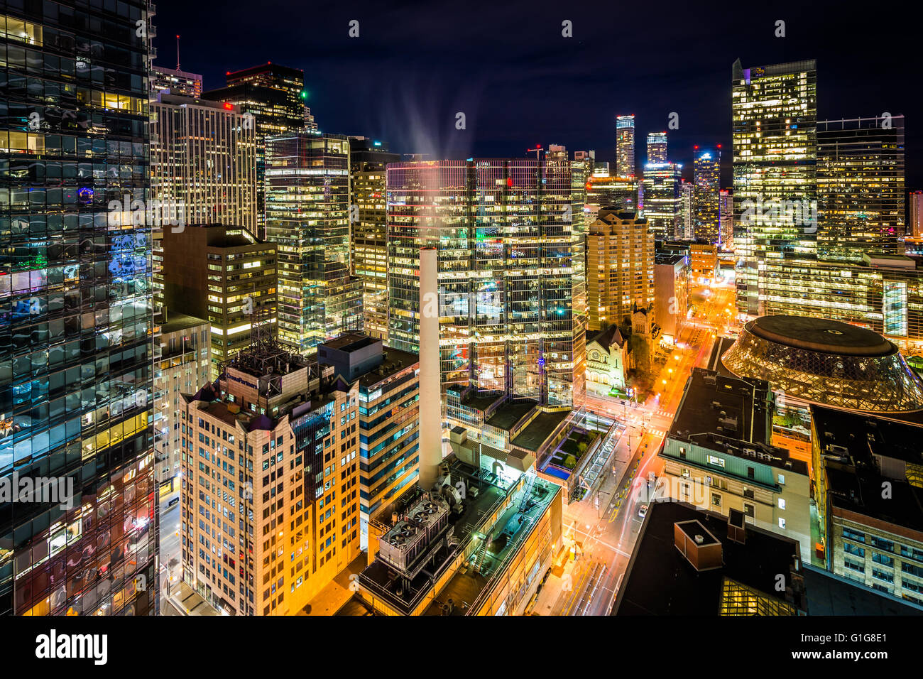 View of modern buildings along Simcoe Street at night, in the Financial ...