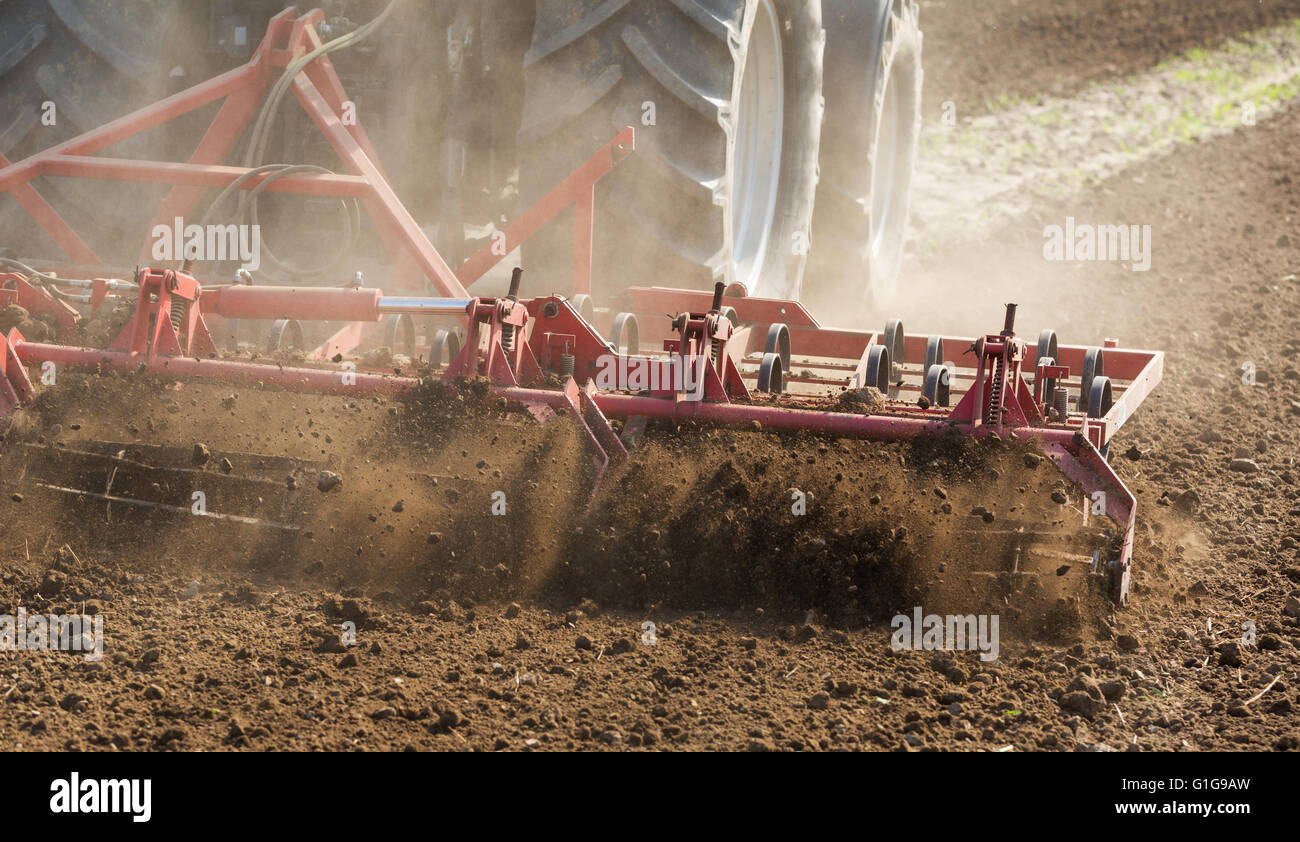 Tractor cultivating field at spring Stock Photo - Alamy