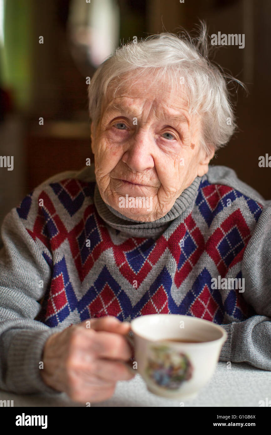 Old woman drinking tea Stock Photo - Alamy