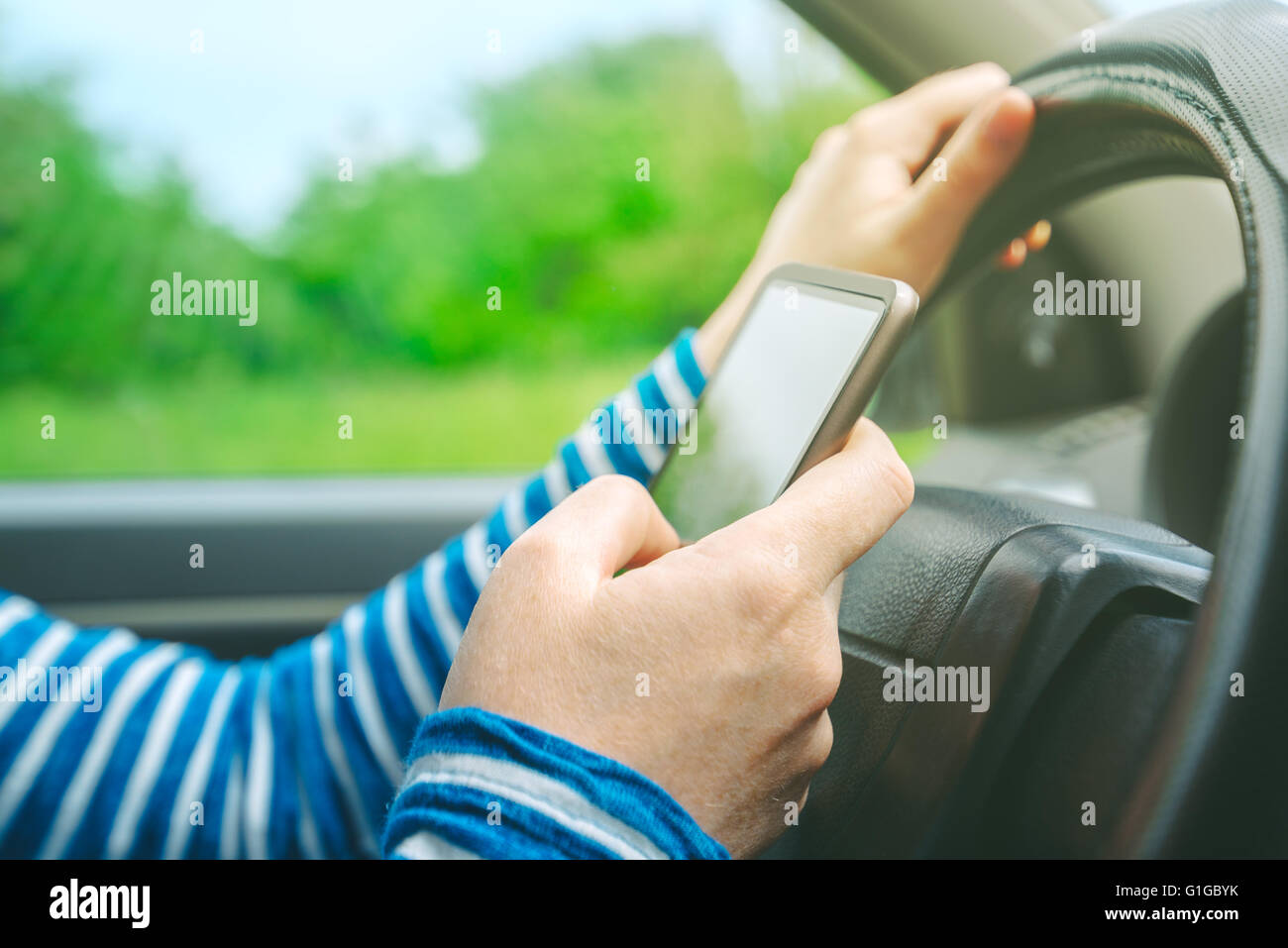 Female driving car and texting sms message on smartphone, using mobile ...