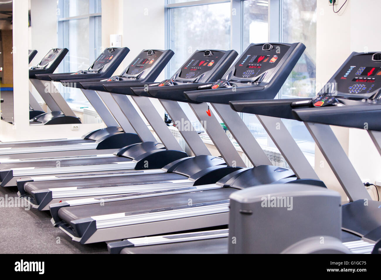 Set of treadmills staying in line in the gym Stock Photo - Alamy