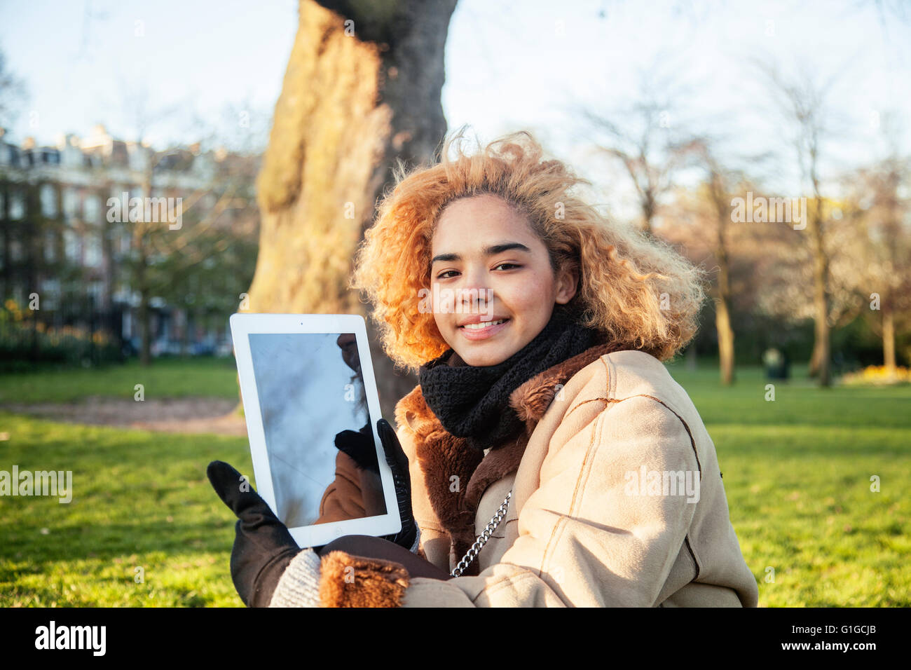 young cute blond african american girl student holding tablet and ...