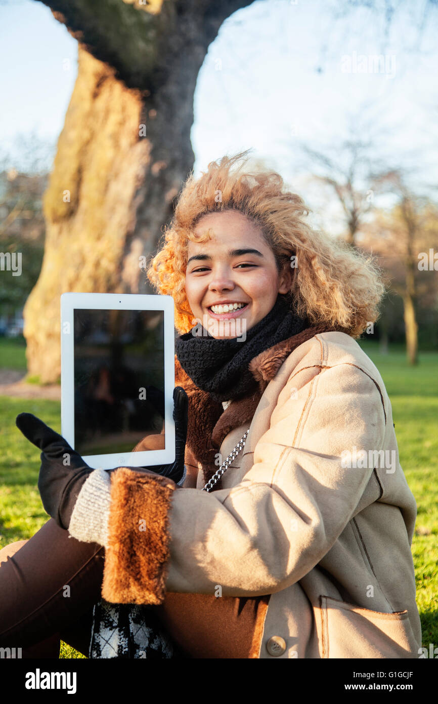 young cute blond african american girl student holding tablet and ...