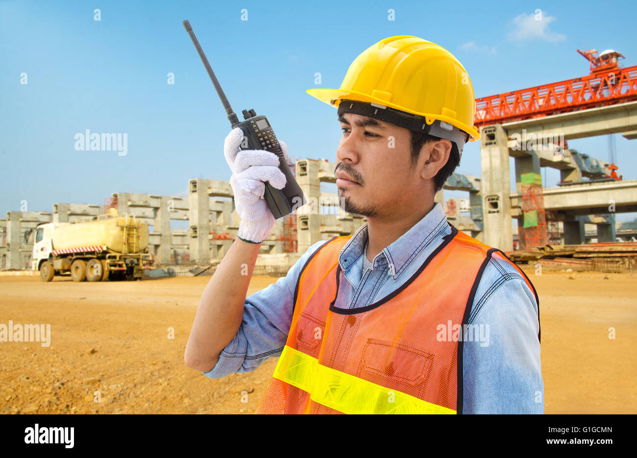 Confident supervisor using walkie-talkie at construction site Stock ...