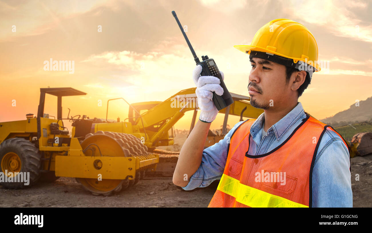 Confident supervisor using walkie-talkie at construction site Stock ...