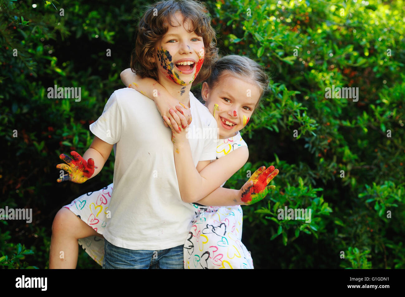 Kids hugging, their faces and hands in paint Stock Photo - Alamy