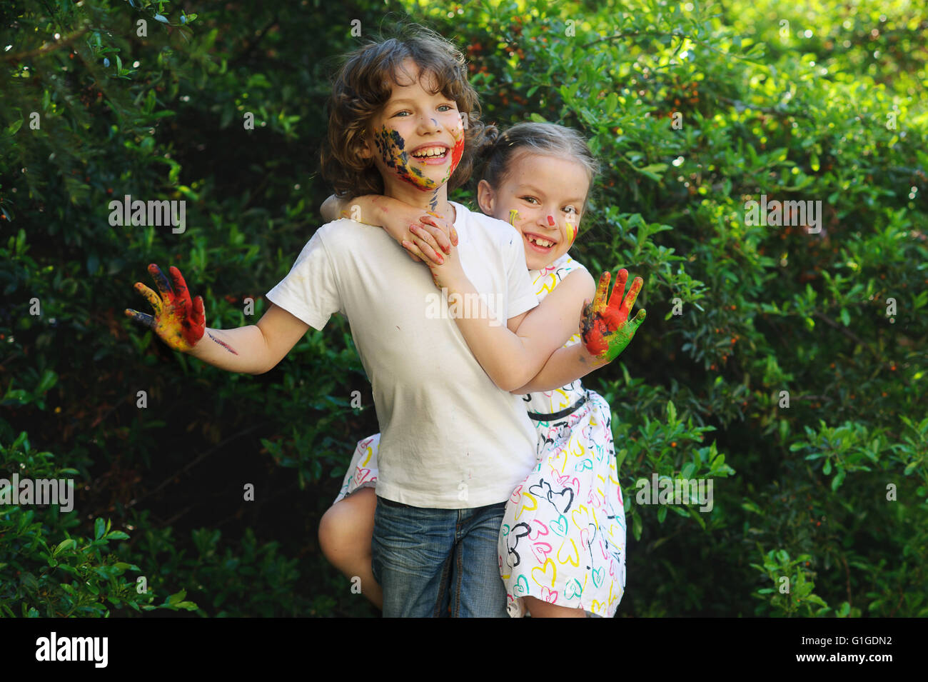Little kids hugging, their faces and hands are colored Stock Photo - Alamy