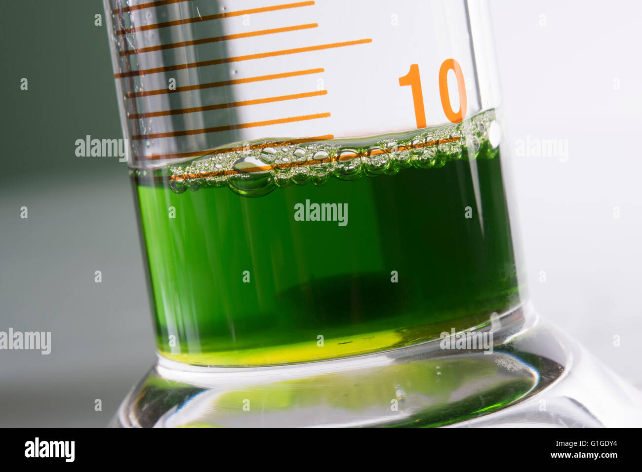 graduated cylinder close up with green chemicals Stock Photo - Alamy