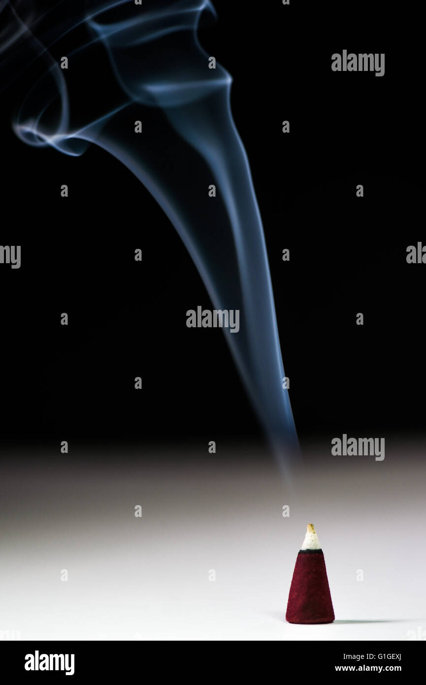 Incense stick with smoke on black background Stock Photo - Alamy