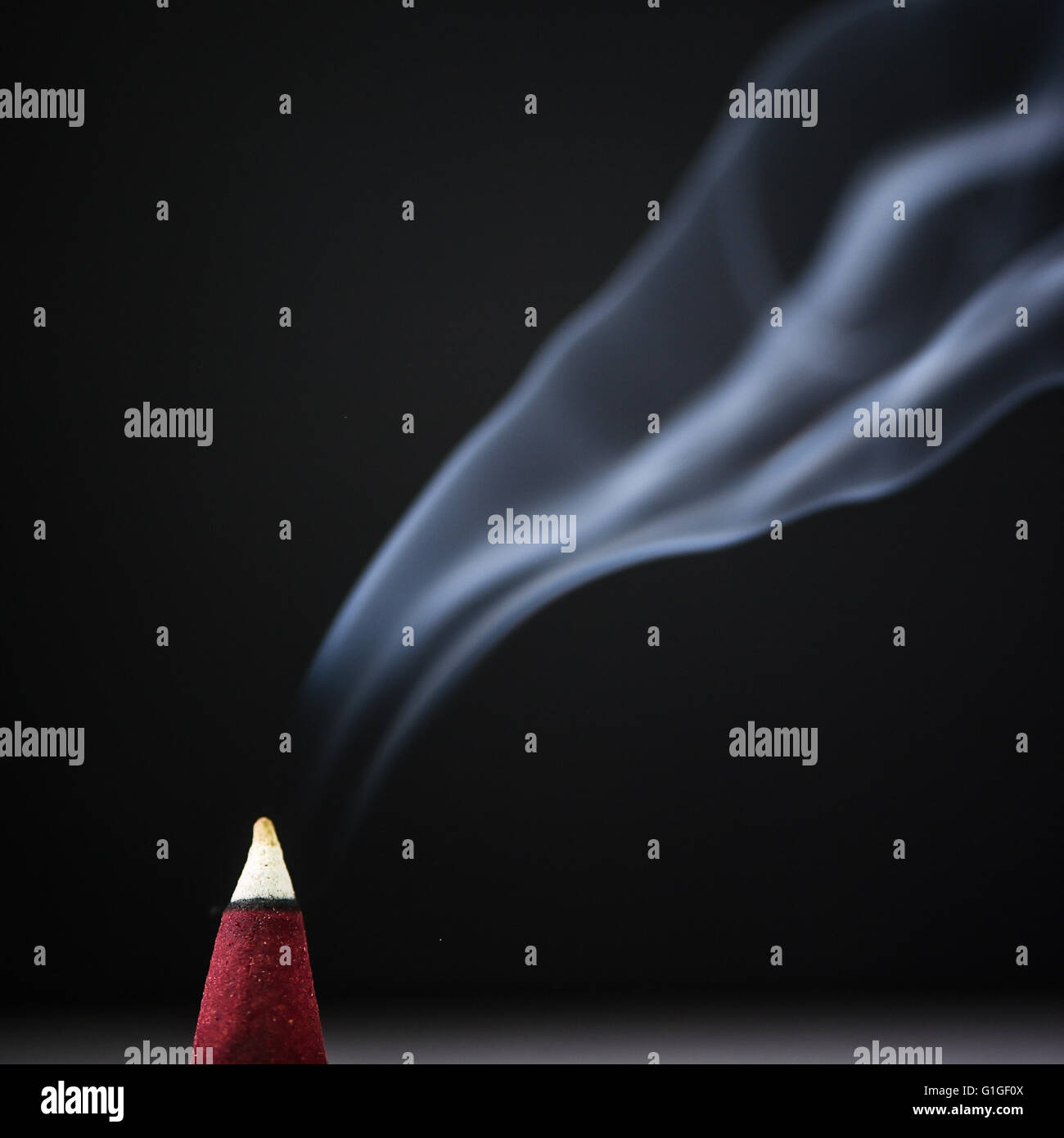 Incense stick with smoke on black background Stock Photo - Alamy