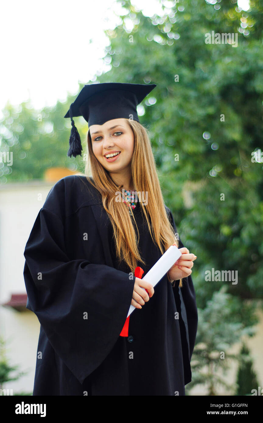Merry graduate in cap and gown Stock Photo - Alamy