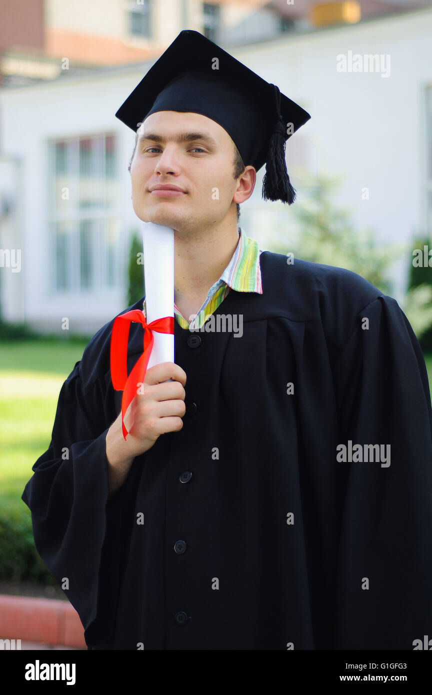 University graduate holding diploma tied with a red ribbon Stock Photo ...