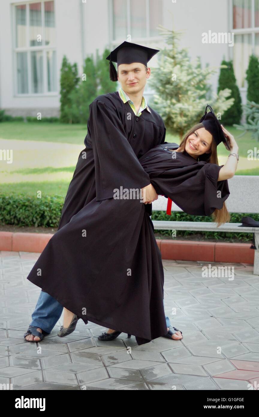 Young man and woman happily dancing in clothes graduates Stock Photo ...
