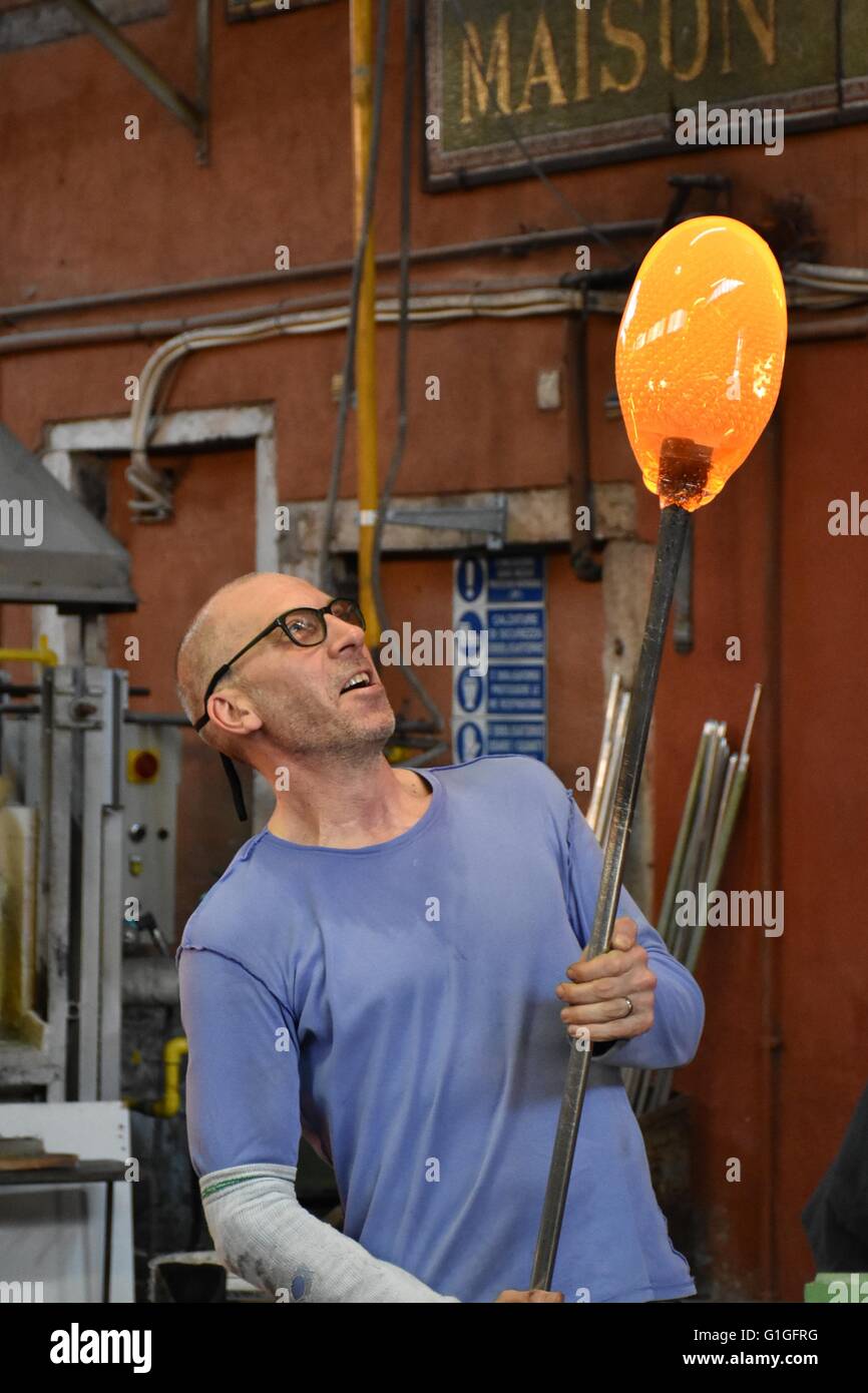 Glass blowers making glass at the glass factory on Murano island, Italy ...