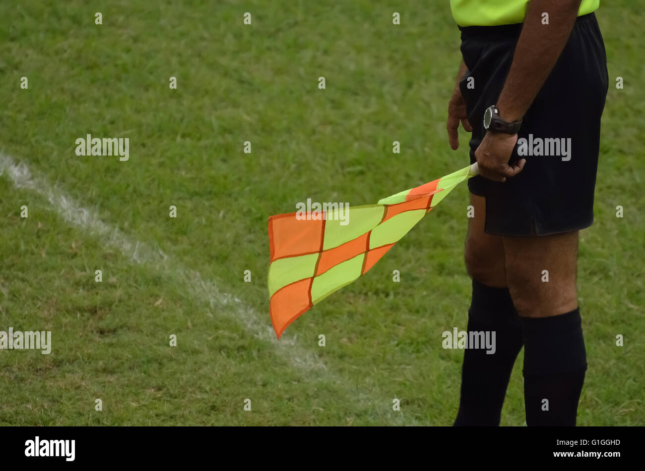 Soccer assistant referee running with flag Stock Photo - Alamy