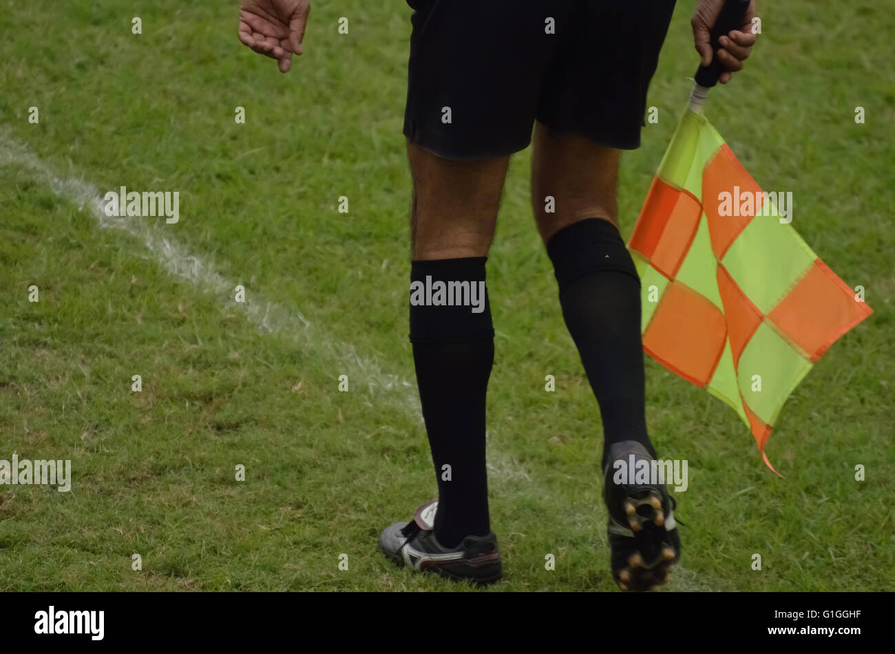 Soccer assistant referee running with flag Stock Photo - Alamy