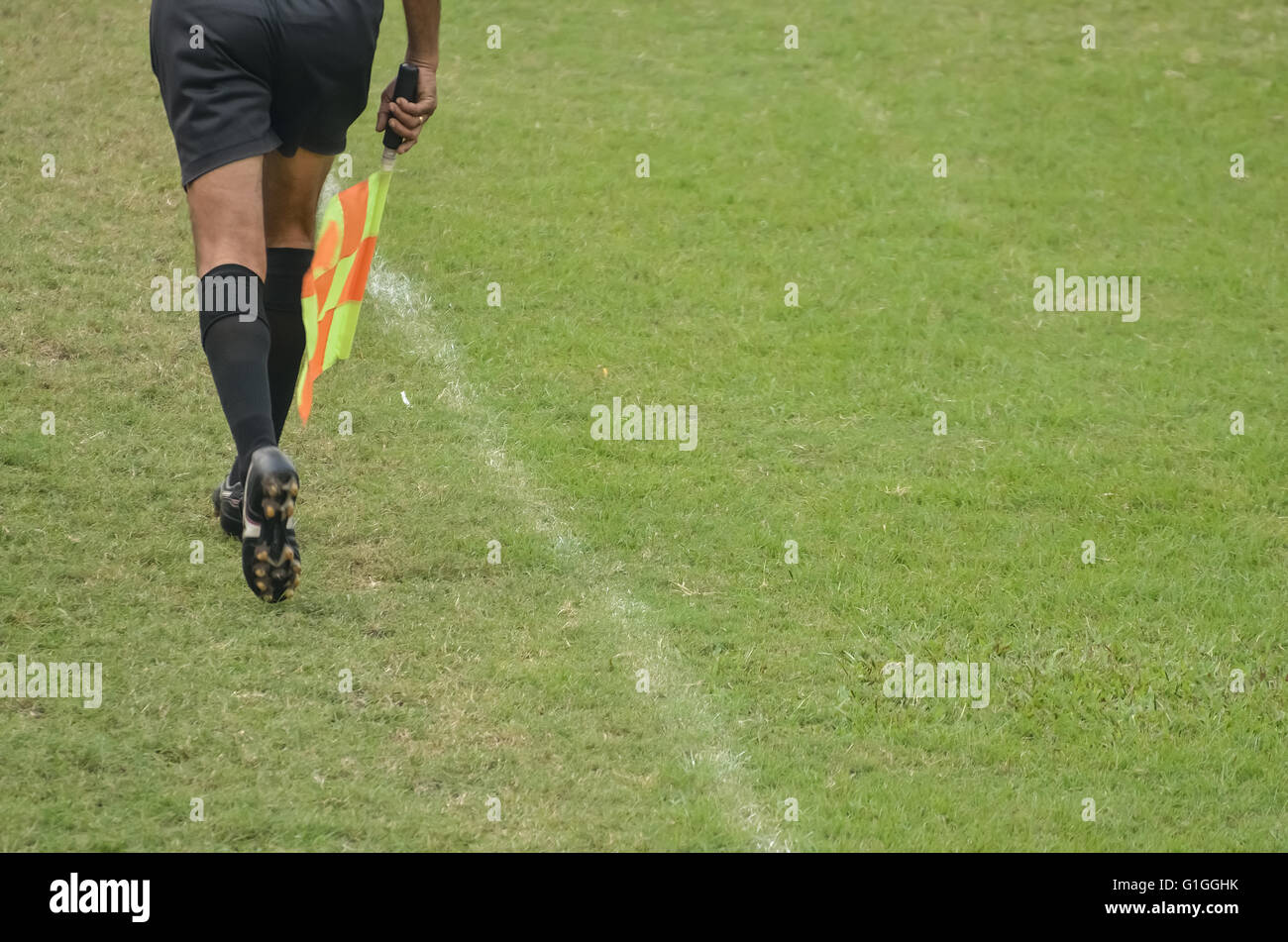 Soccer assistant referee running with flag Stock Photo - Alamy