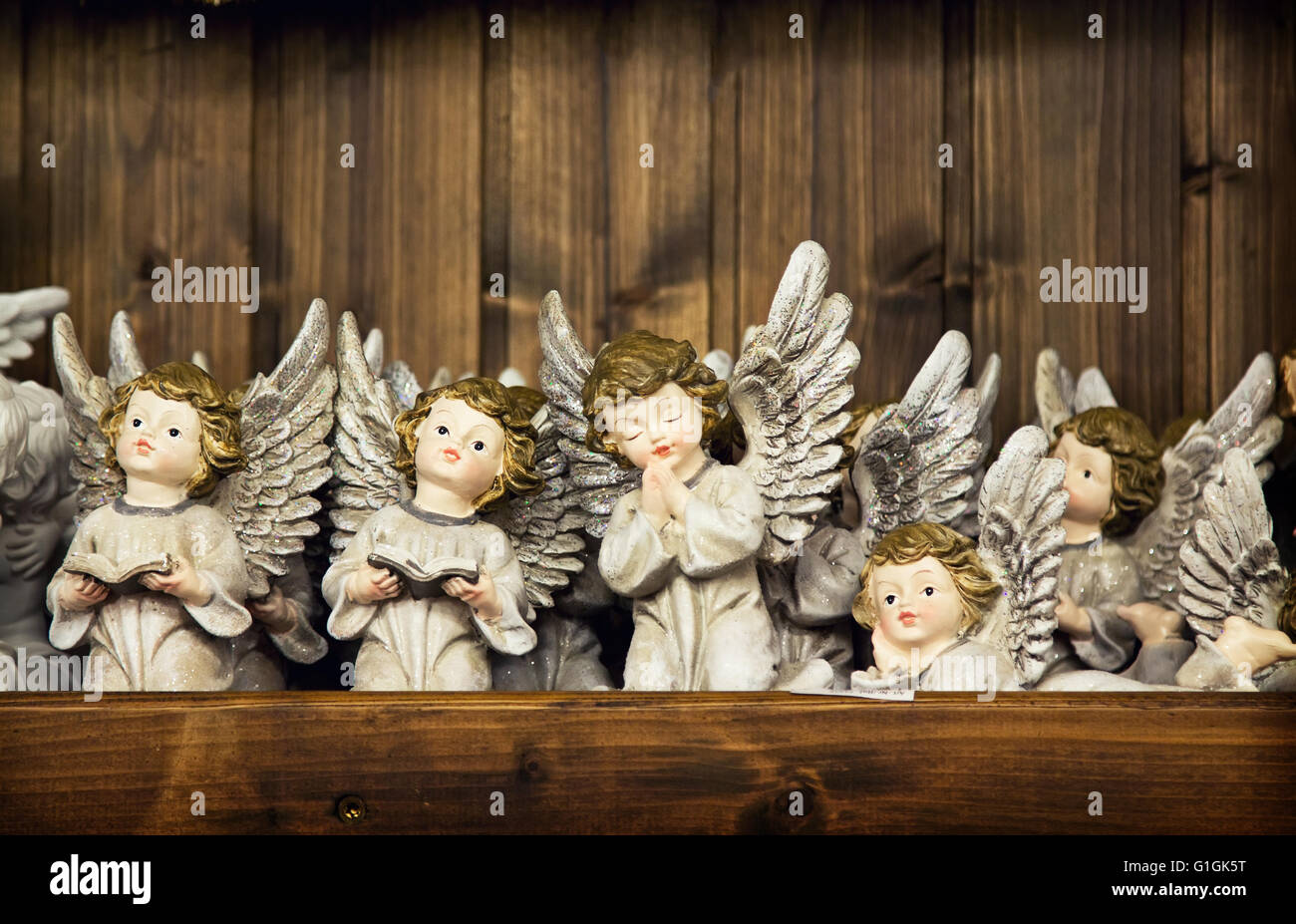 Christmas angels toy with the sparked wings on a wooden wall background ...
