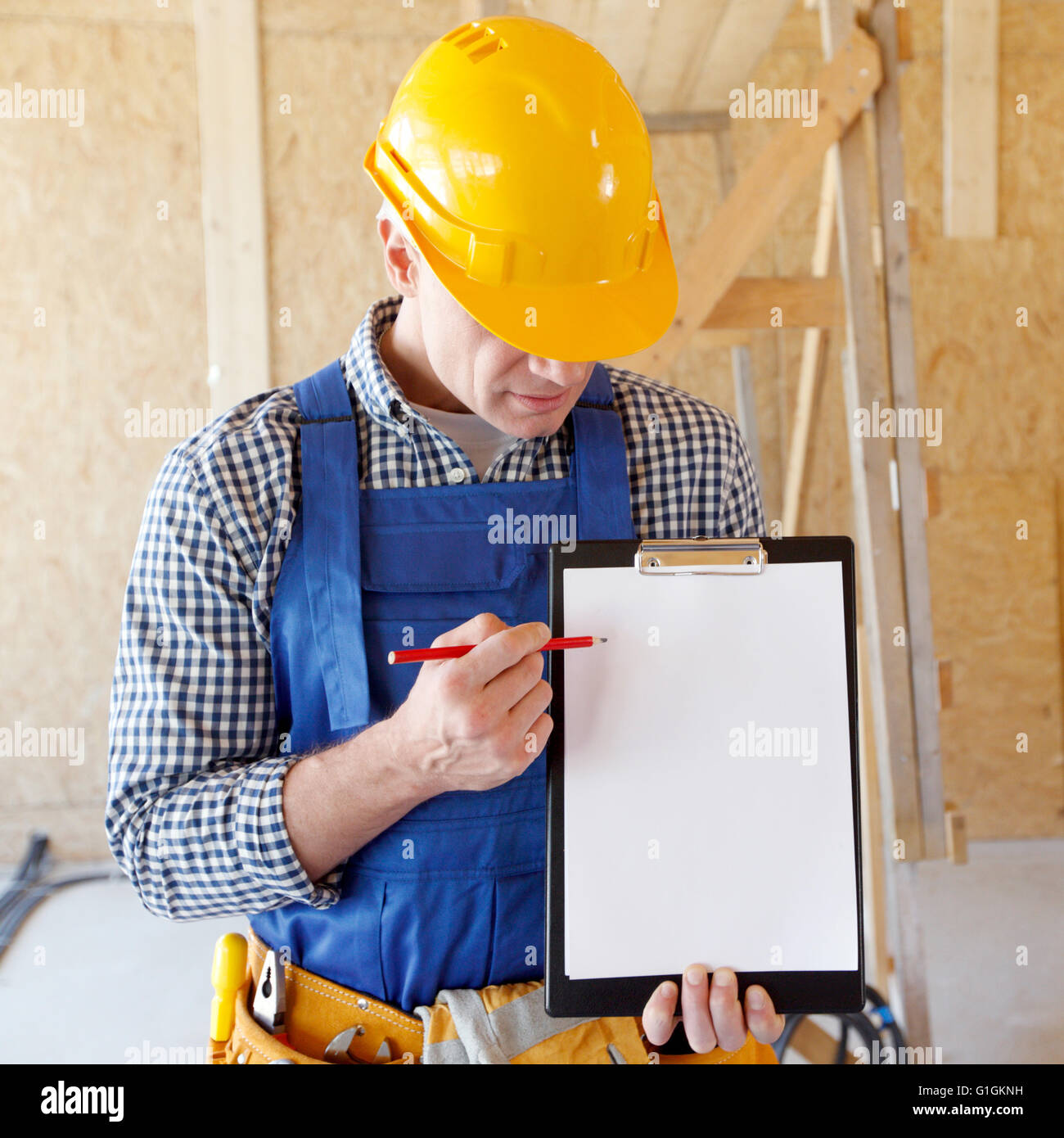 Portrait of foreman pointing at white folder plate Stock Photo - Alamy