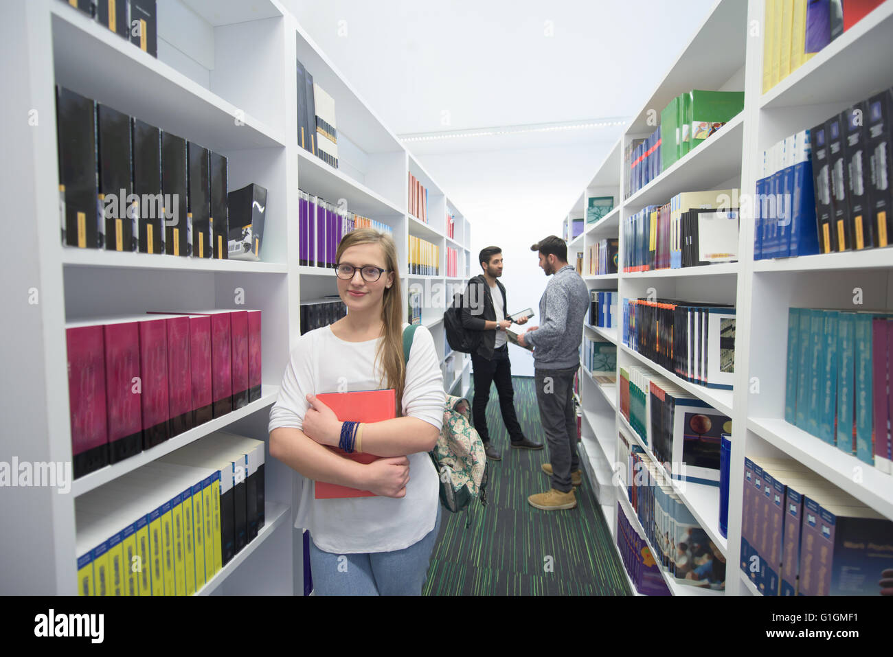 happy students group in school library selecting books to read and ...